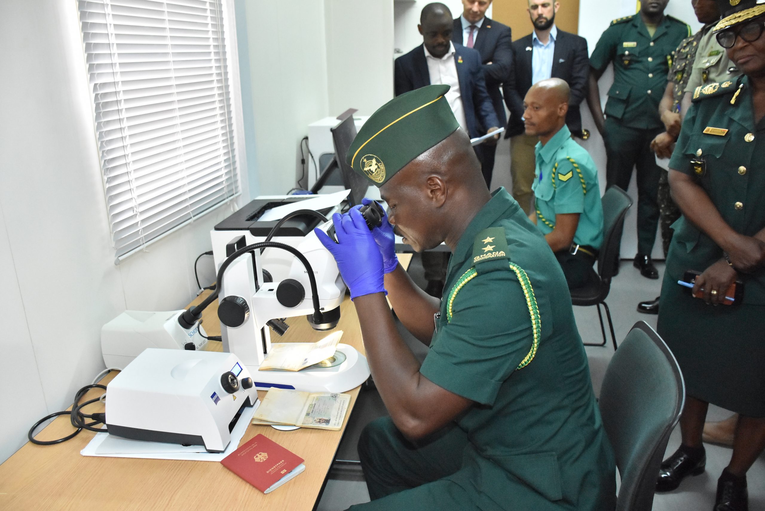 An Officer undertaking forensic examination on a travel document ...